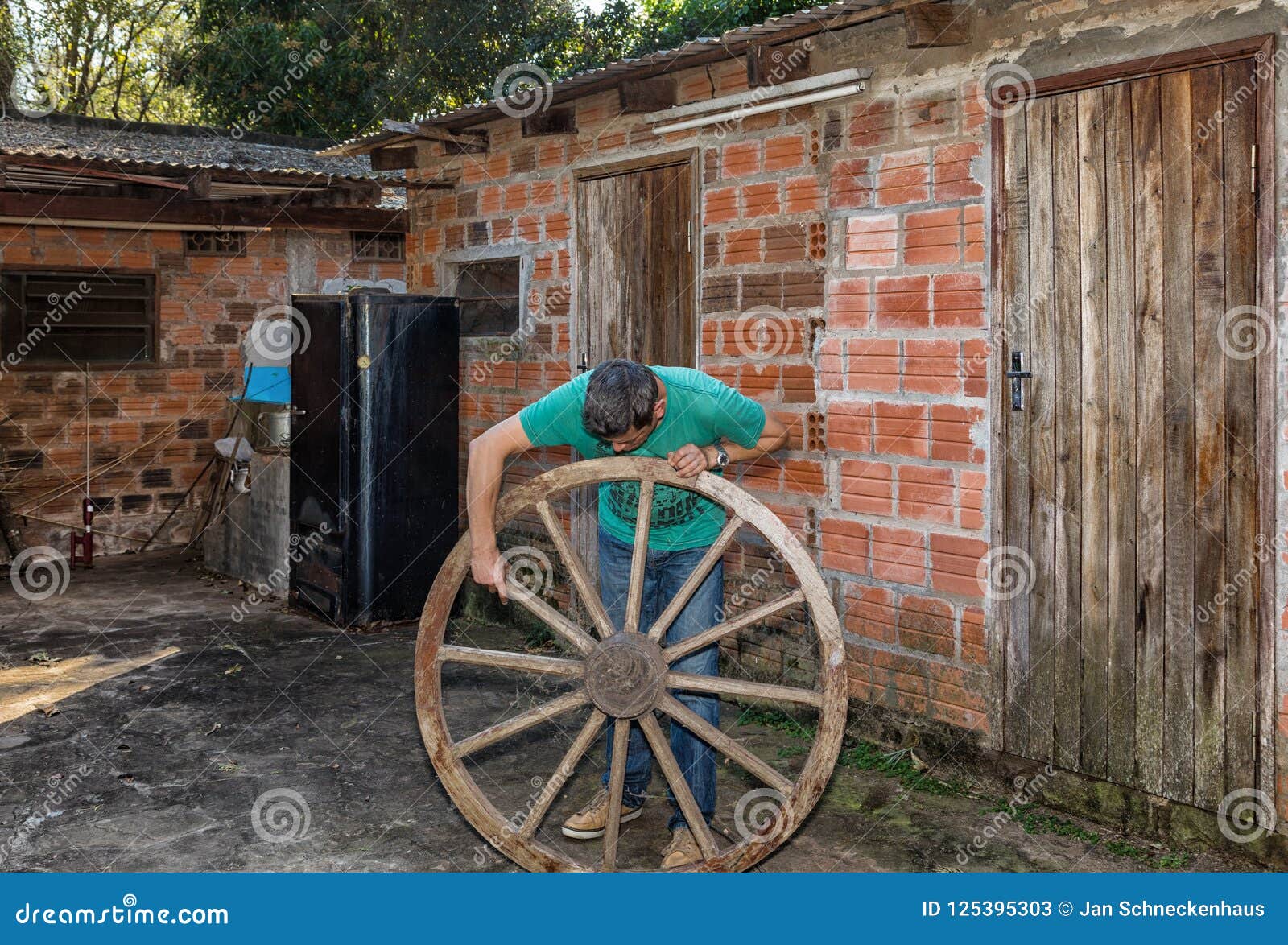 Man Inspects an Old Wooden Wheel. Stock Image - Image of inspects, cart ... Man Inspects an Old Wooden Wheel. Stock Image - Image of inspects, cart ...