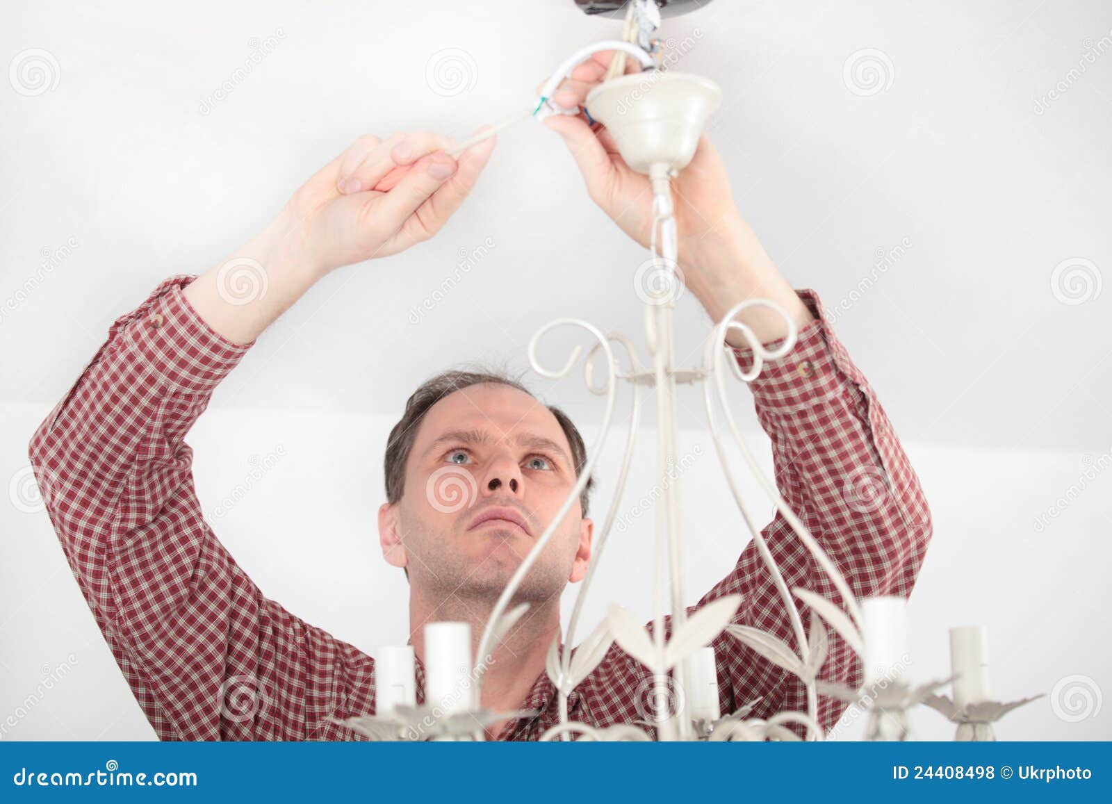Man installing chandelier stock photo. Image of home - 24408498