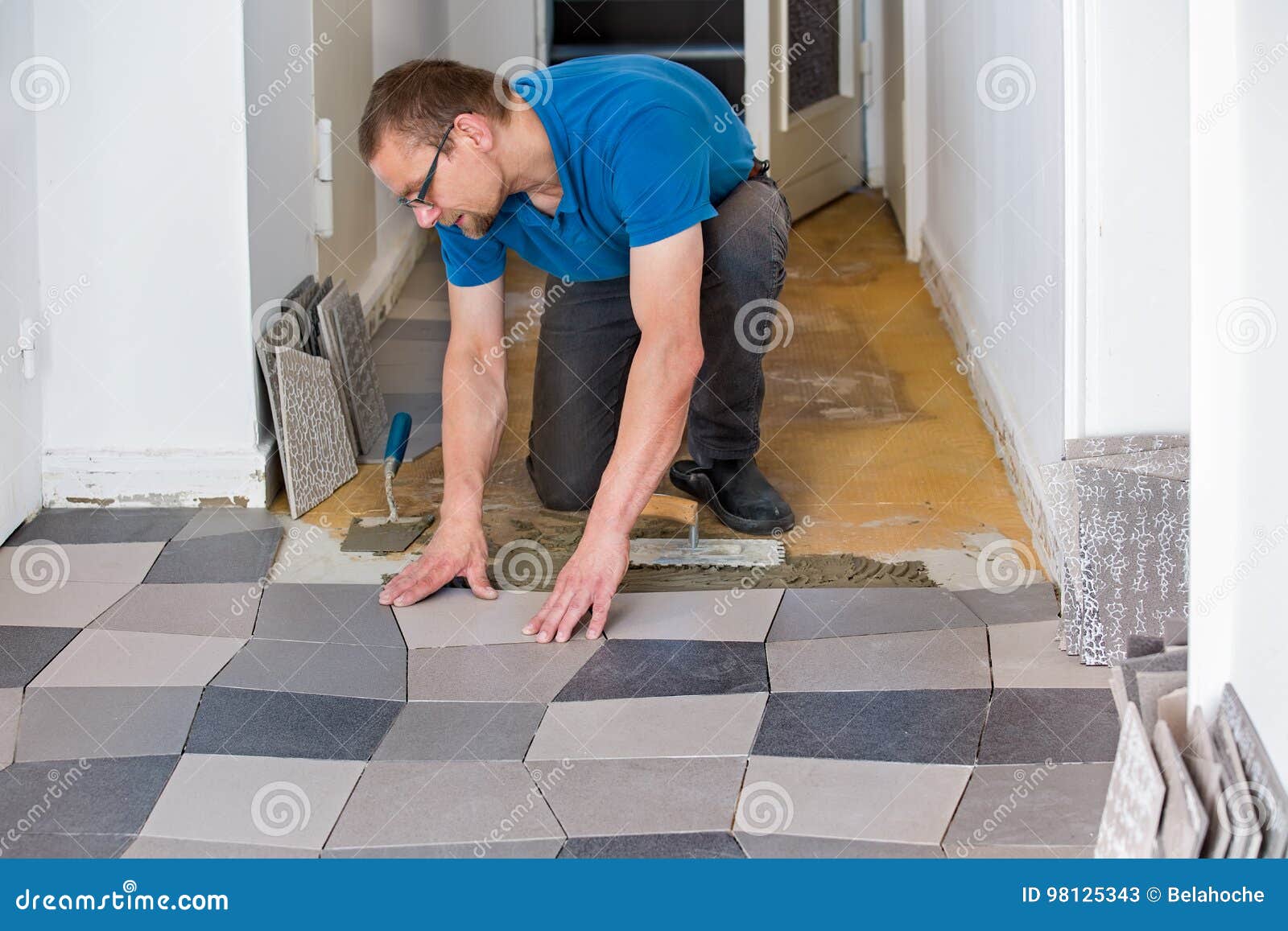 Man installing floor tiles stock image. Image of trade - 98125343