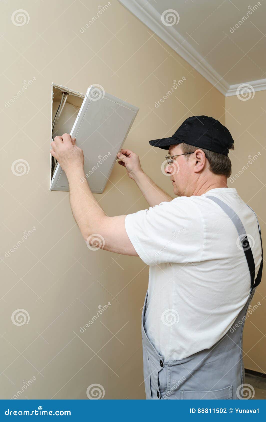 Man is Installing Hatch on the Wall. Stock Photo - Image of ...