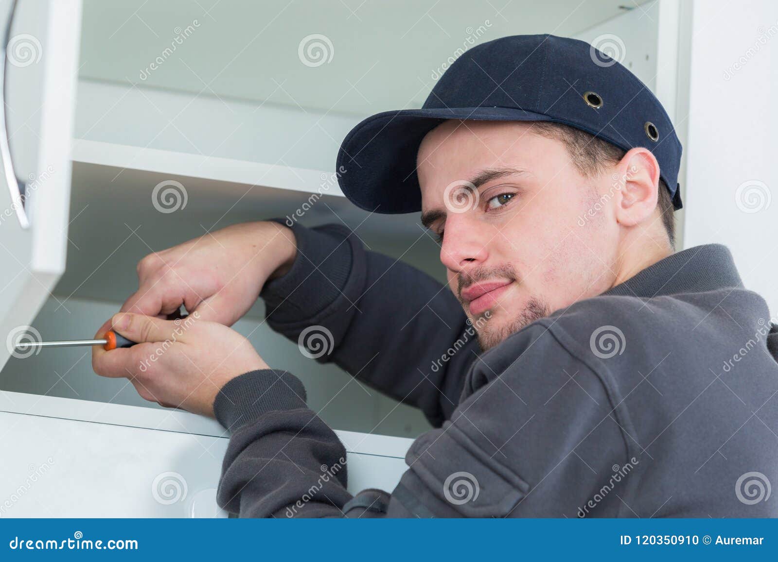 Man installing a kitchen stock photo. Image of contractor - 120350910