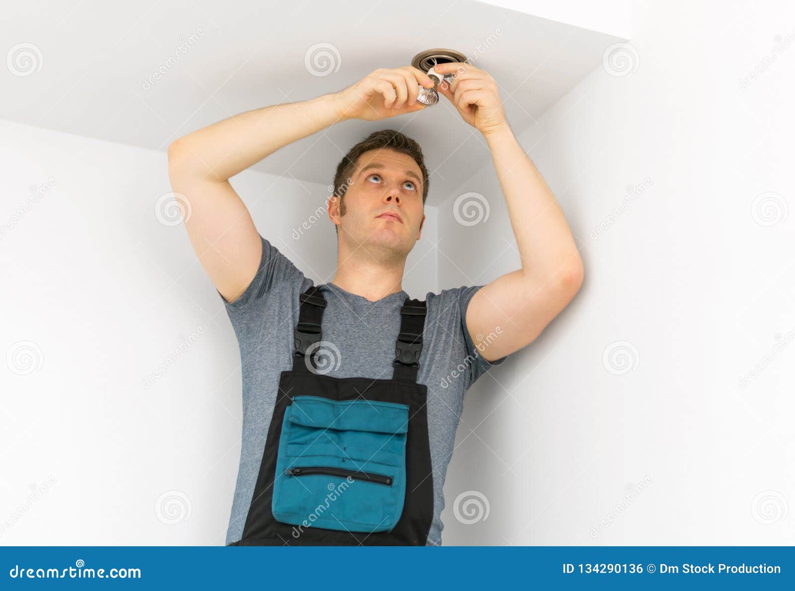 Man installing light bulb stock photo. Image of professional - 134290136