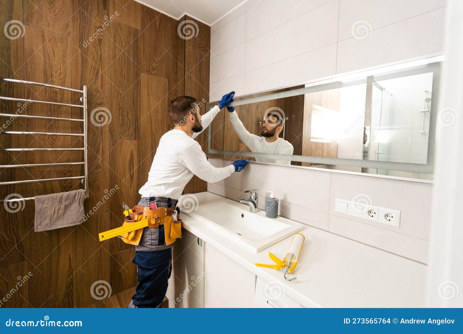 Man Installing a Mirror on Wall in His Renewed Bathroom Stock Photo ...