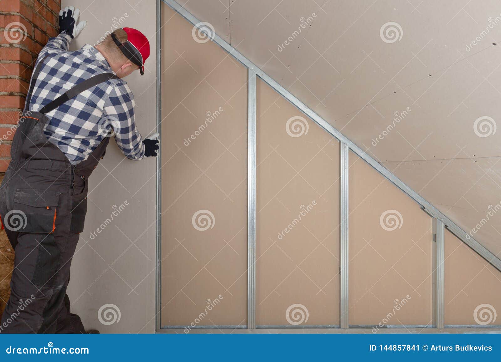 Man Installing Plasterboard Sheet To Wall for Attic Room Construction ...