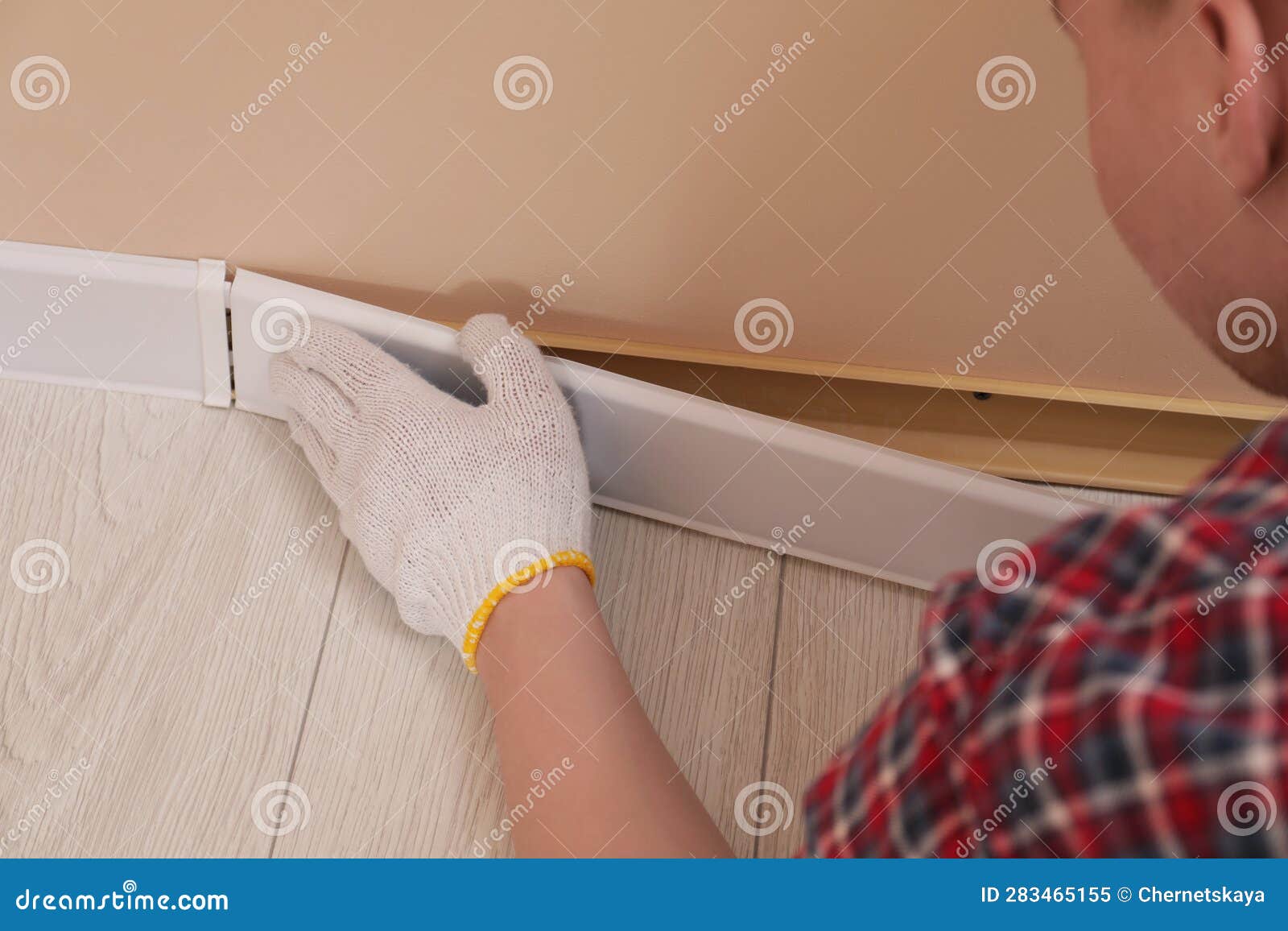 Man Installing Plinth on Laminated Floor in Room, Closeup Stock Image ...