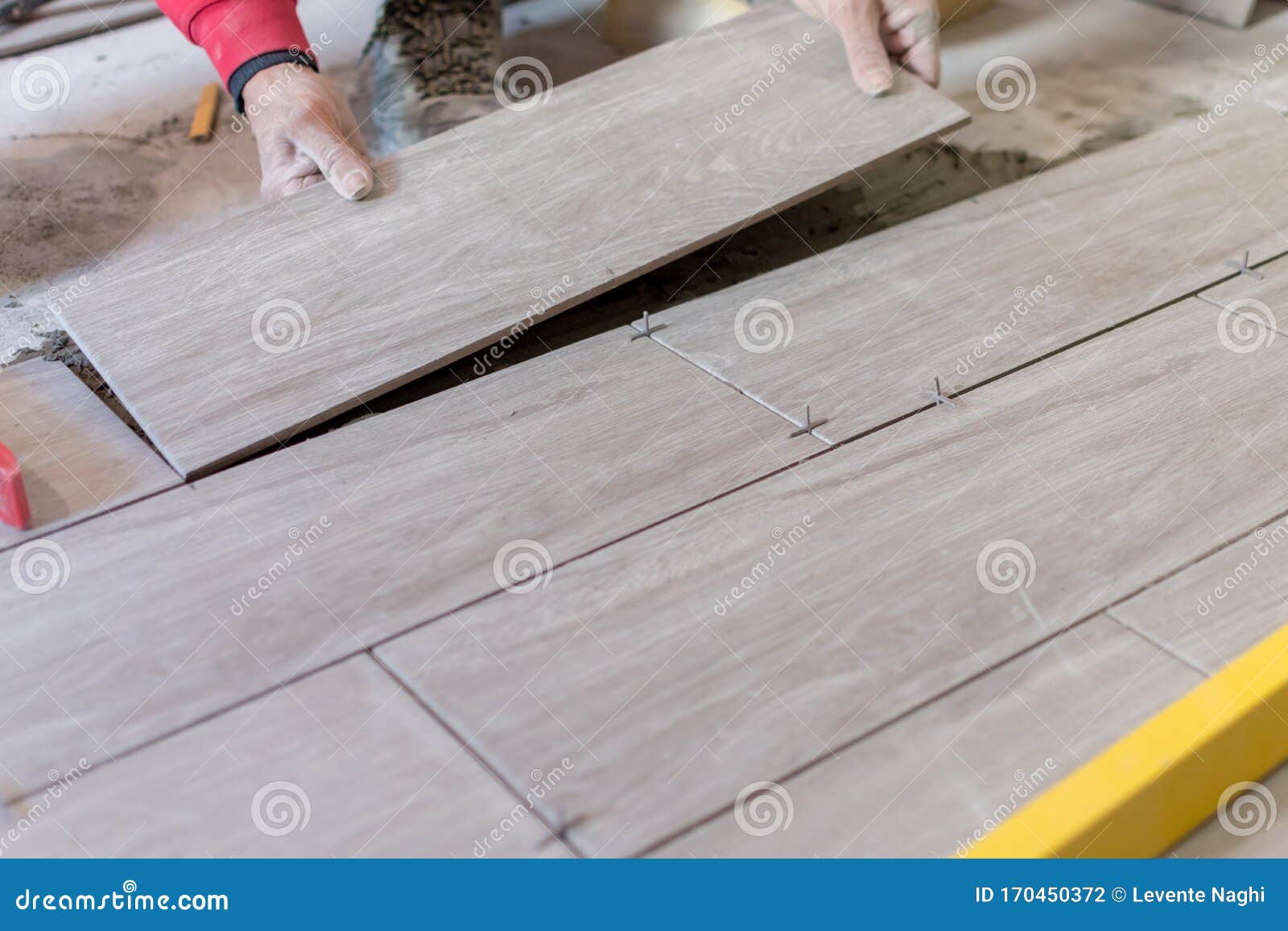 Man Installing Rectangular Shaped Floor Tiles in Kitchen. Applying ...