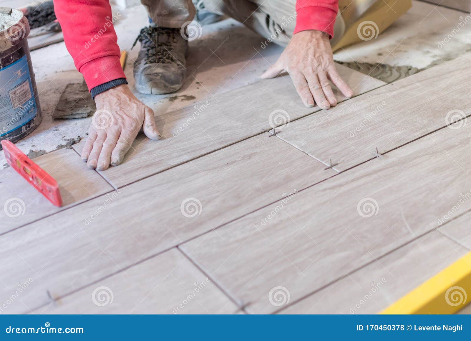 Man Installing Rectangular Shaped Floor Tiles in Kitchen. Applying ...