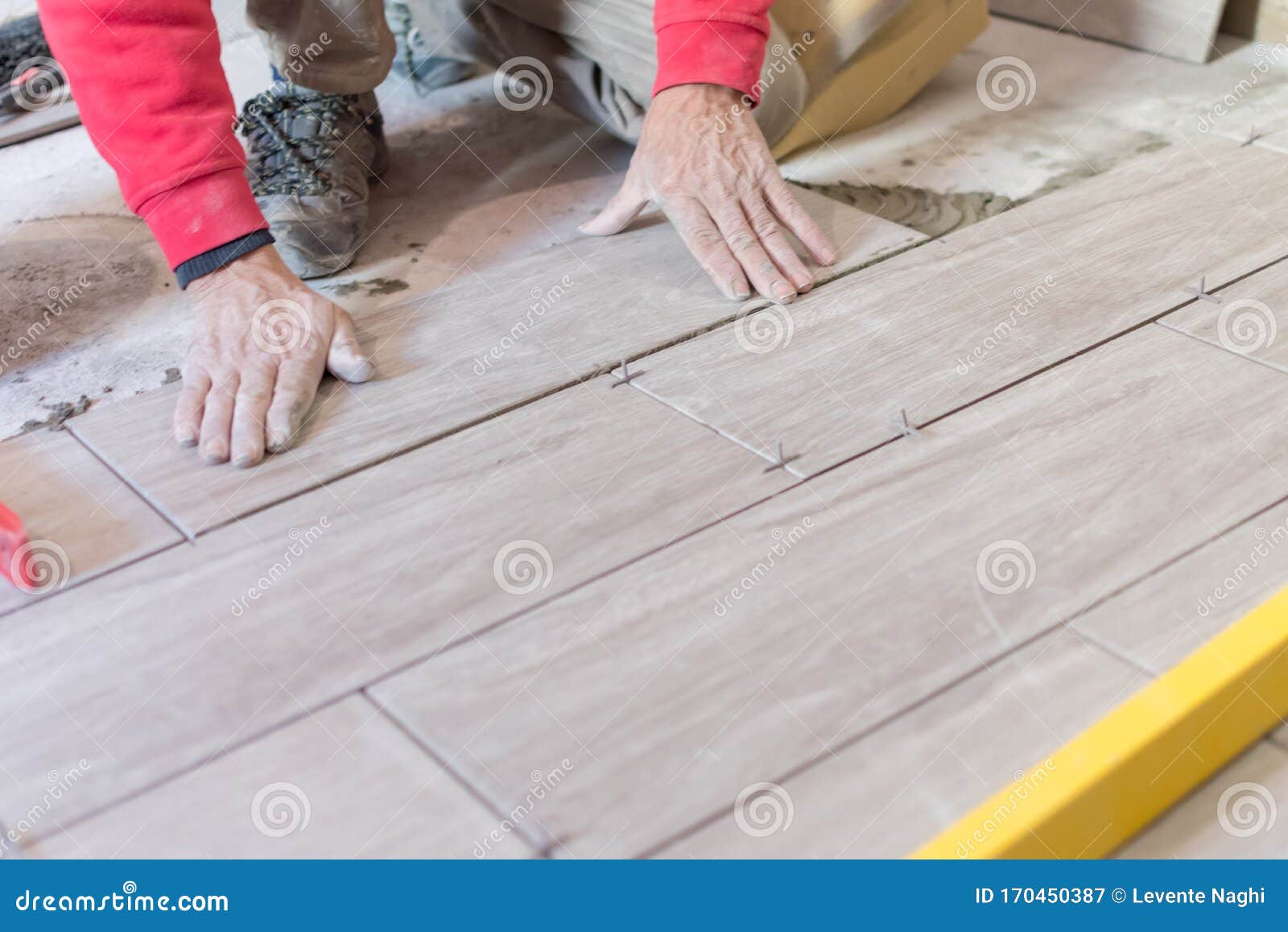 Man Installing Rectangular Shaped Floor Tiles in Kitchen. Applying ...