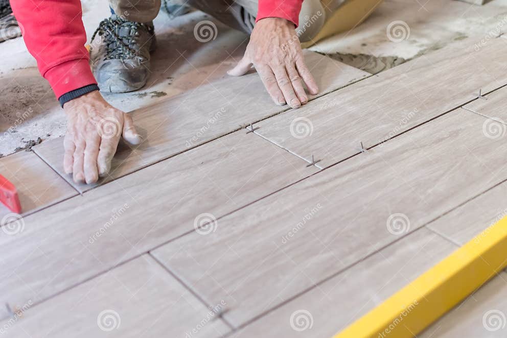 Man Installing Rectangular Shaped Floor Tiles in Kitchen. Applying ...