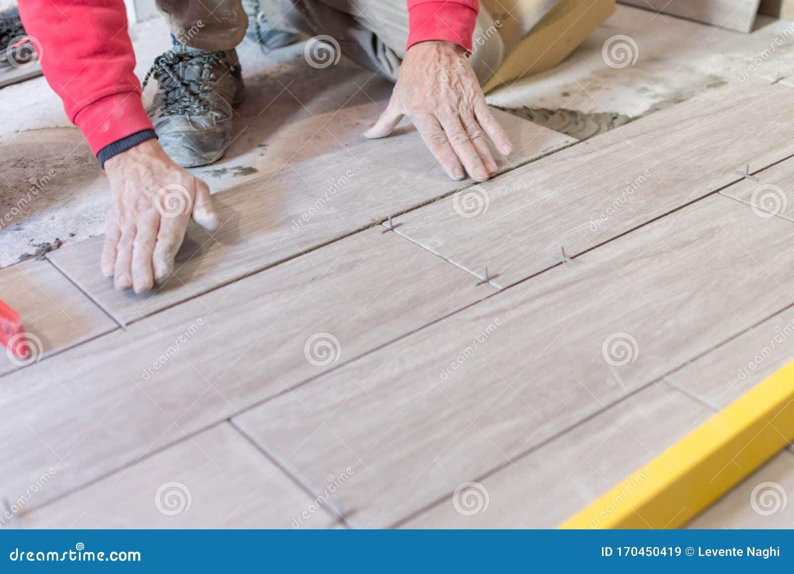 Man Installing Rectangular Shaped Floor Tiles in Kitchen. Applying ...