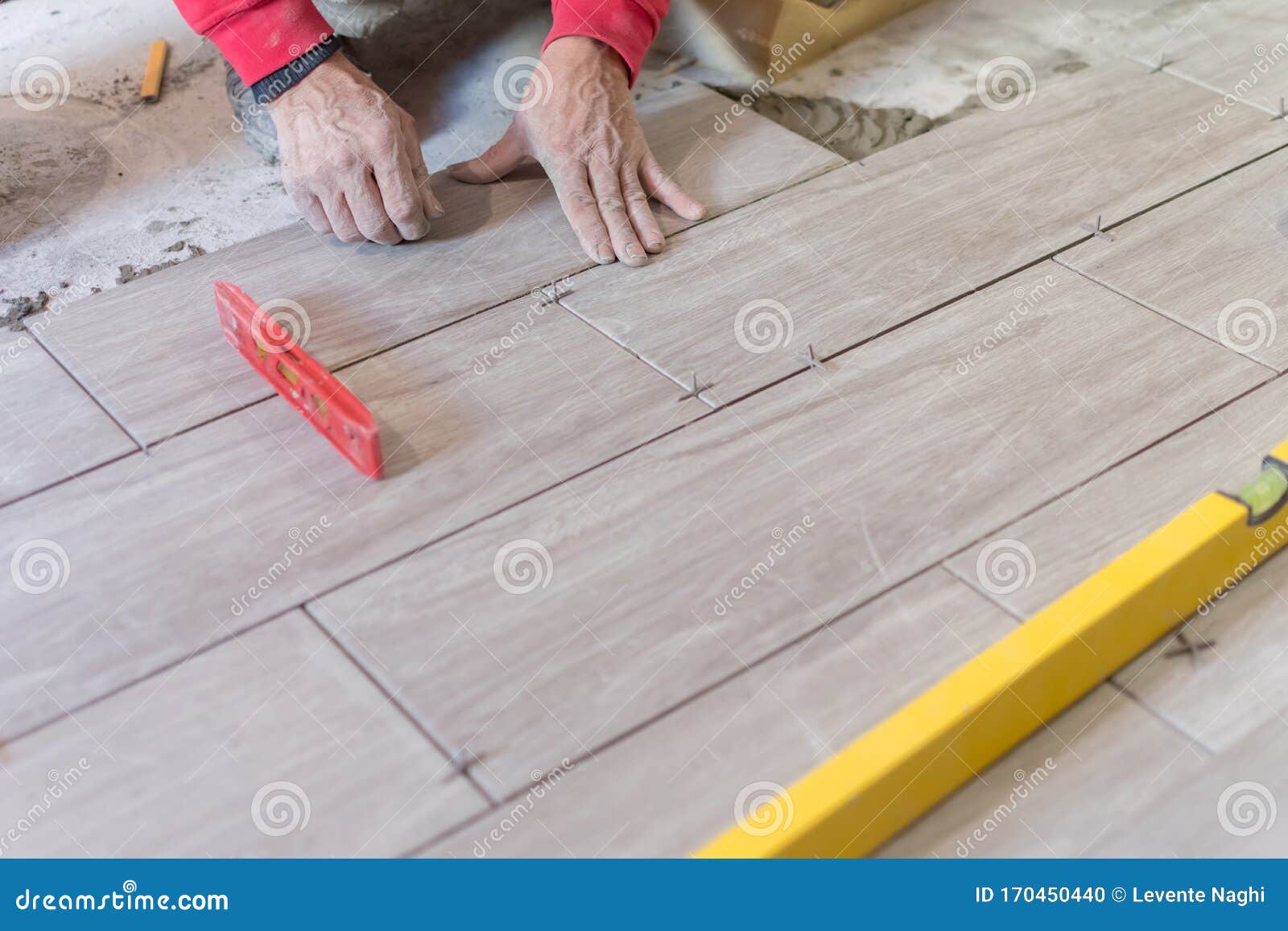 Man Installing Rectangular Shaped Floor Tiles in Kitchen. Applying ...
