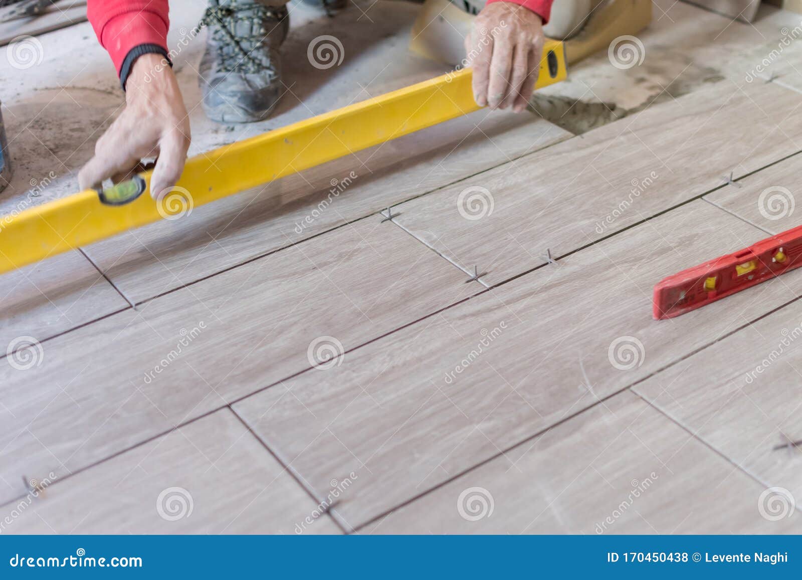 Man Installing Rectangular Shaped Floor Tiles in Kitchen. Applying ...
