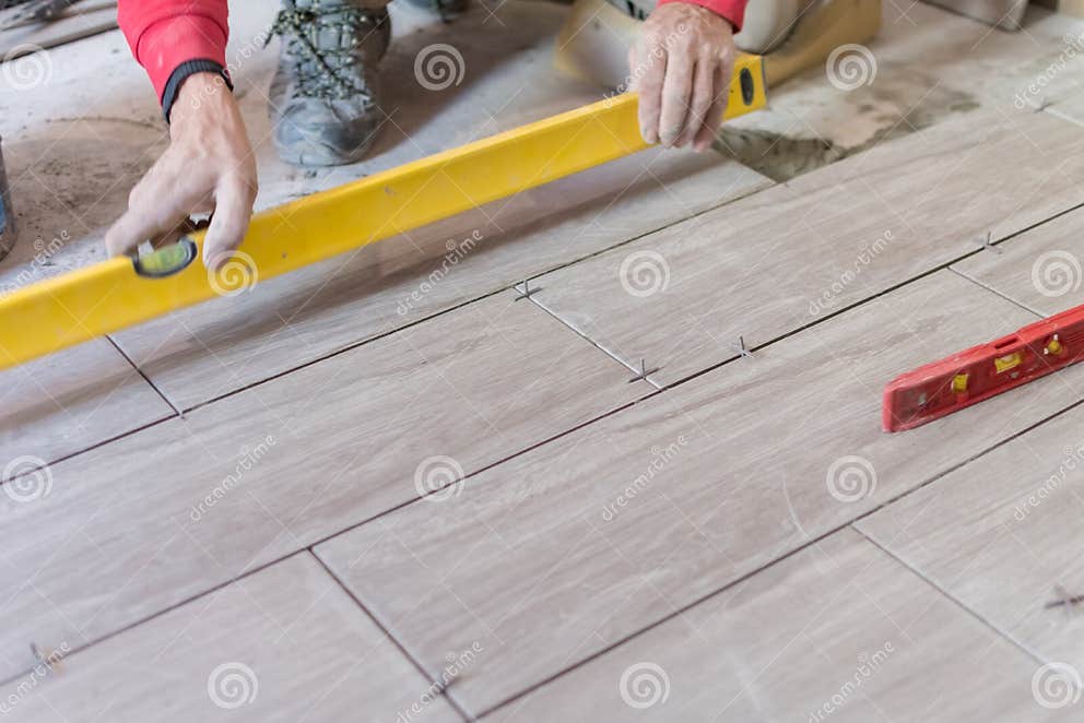 Man Installing Rectangular Shaped Floor Tiles in Kitchen. Applying ...