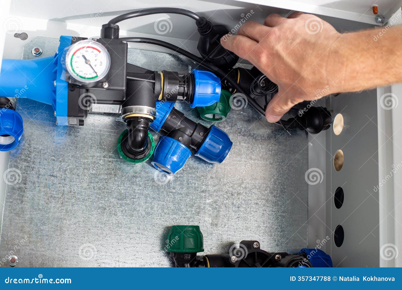 A Man Installs a Drip Irrigation System by Placing Automatic Components ...