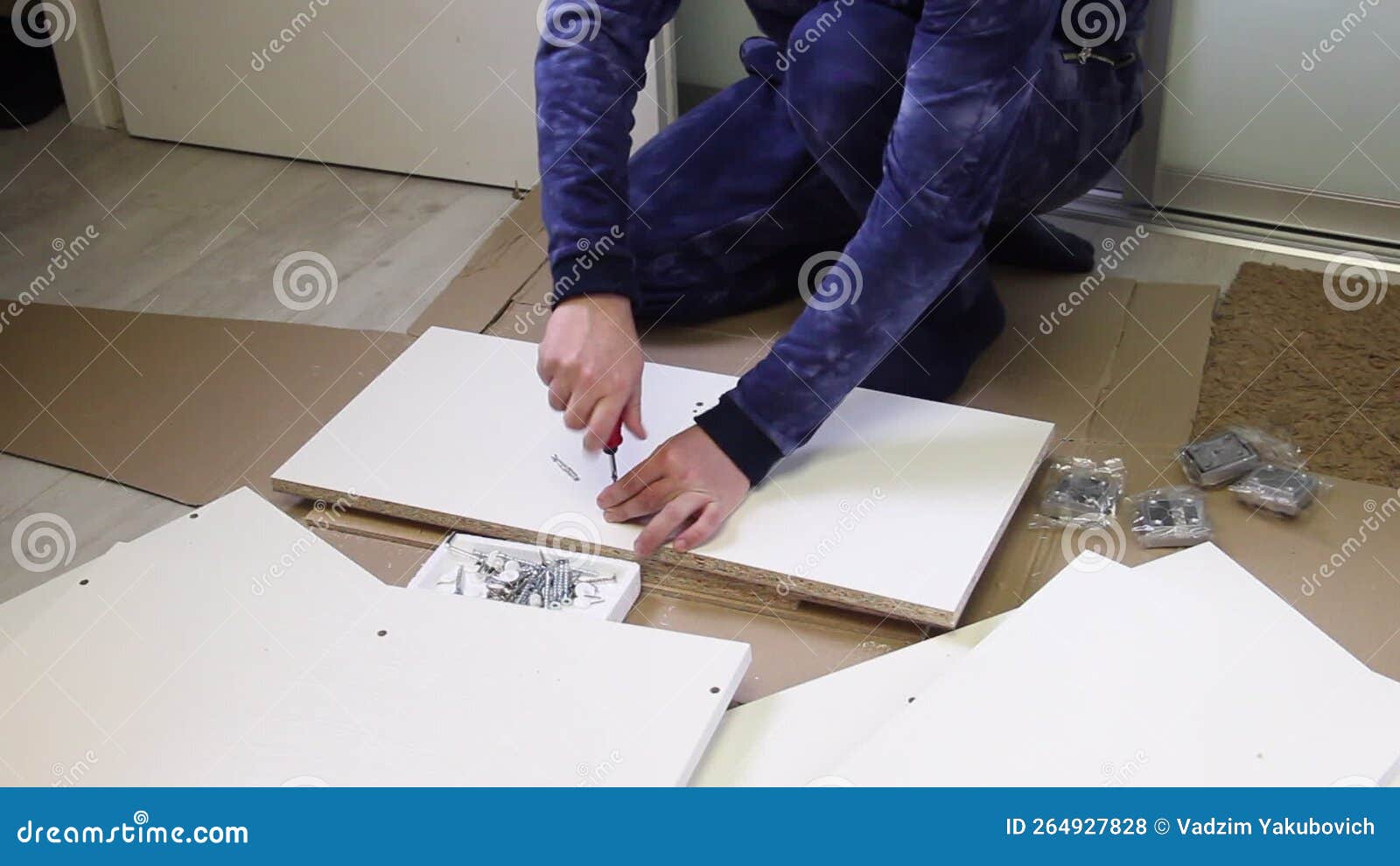 A Man Installs an Eccentric in a Wooden Panel. Screws in the Eccentric ...