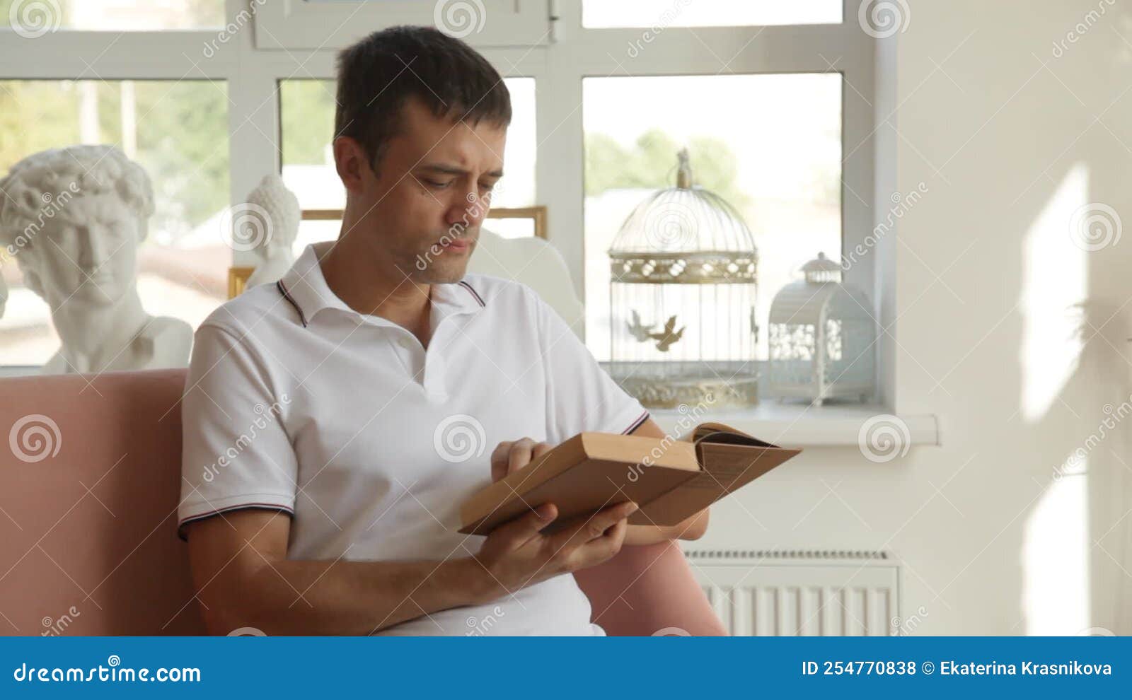 The Man is Intently Flipping through the Pages of an Old Book and ...