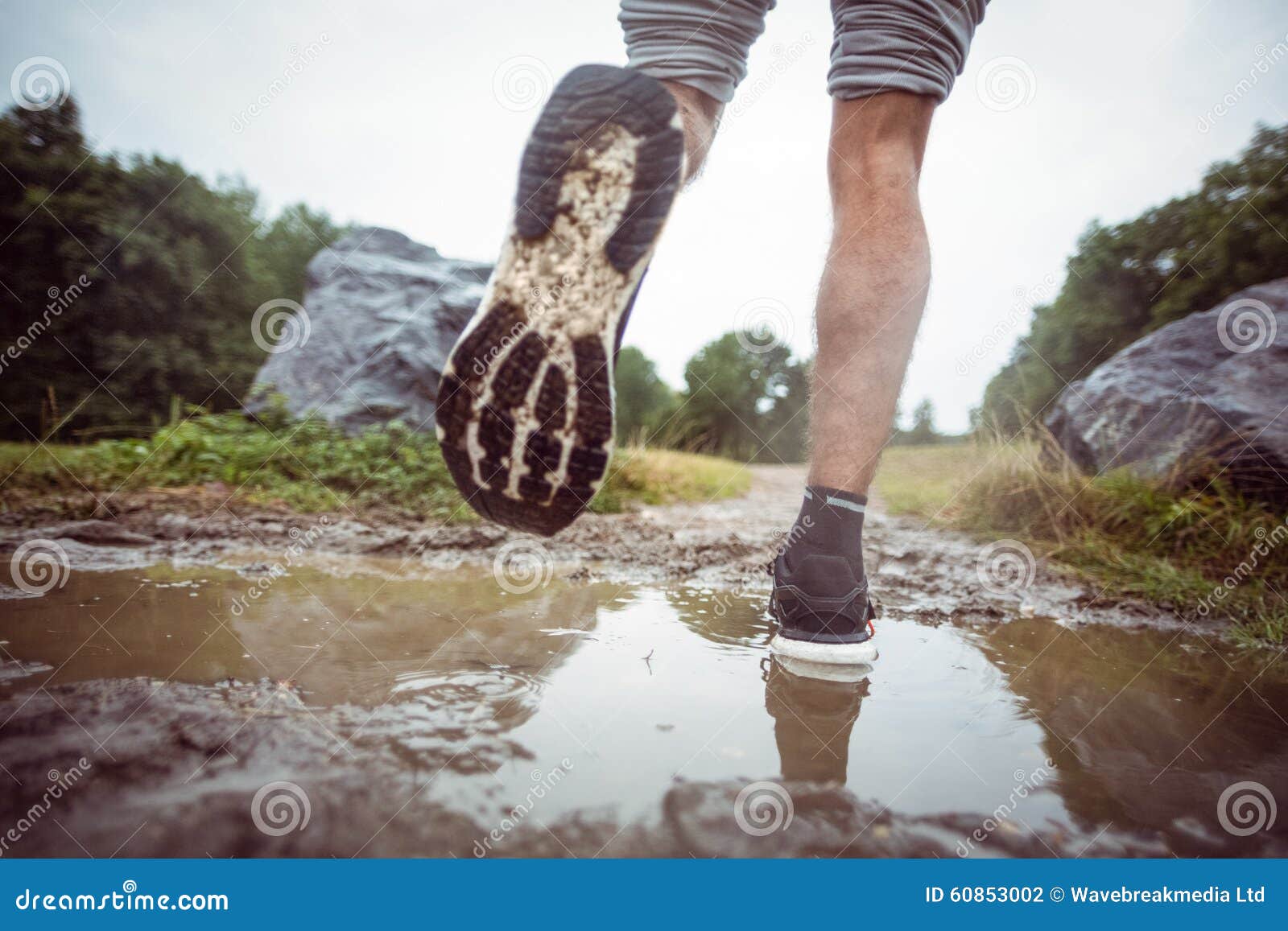 Man Jogging through Muddy Puddles Stock Photo - Image of countryside ...