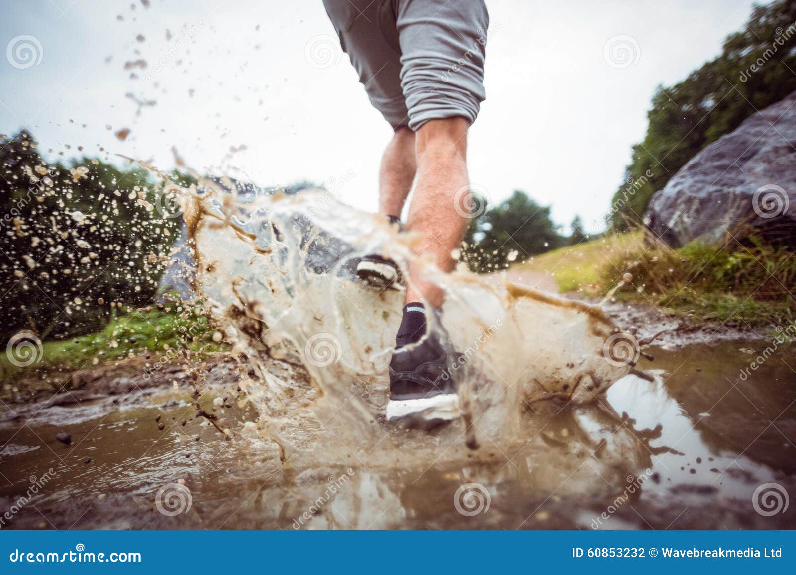 Man Jogging through Muddy Puddles Stock Photo - Image of fitness ...