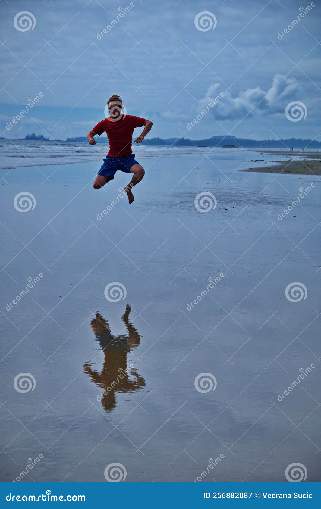 Man jumping on the beach stock image. Image of relaxation - 256882087