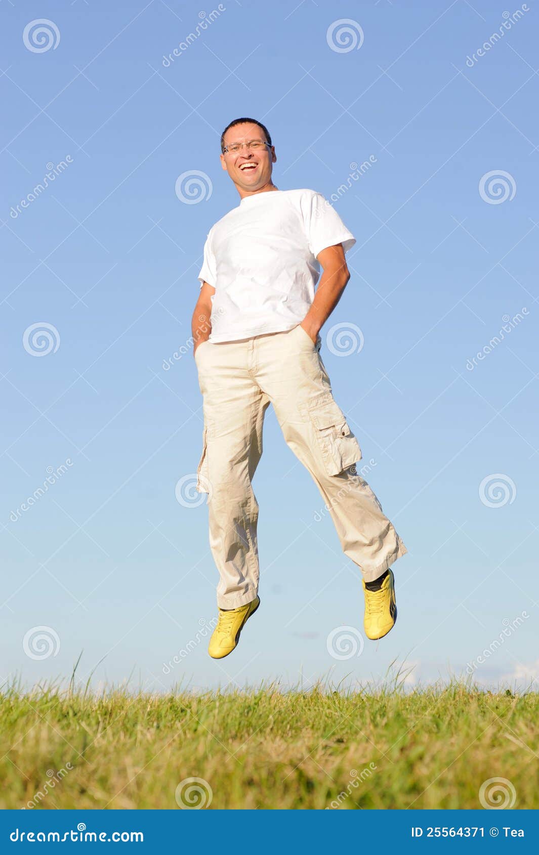 Man jumping on green field stock image. Image of handsome - 25564371