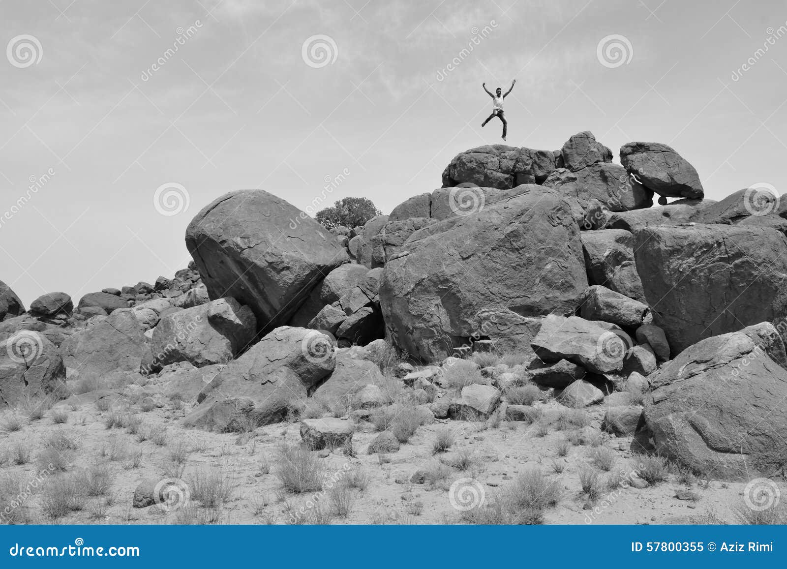 Man Jumping on a Pile of Rocks in the Desert -B&W- Stock Image - Image ...