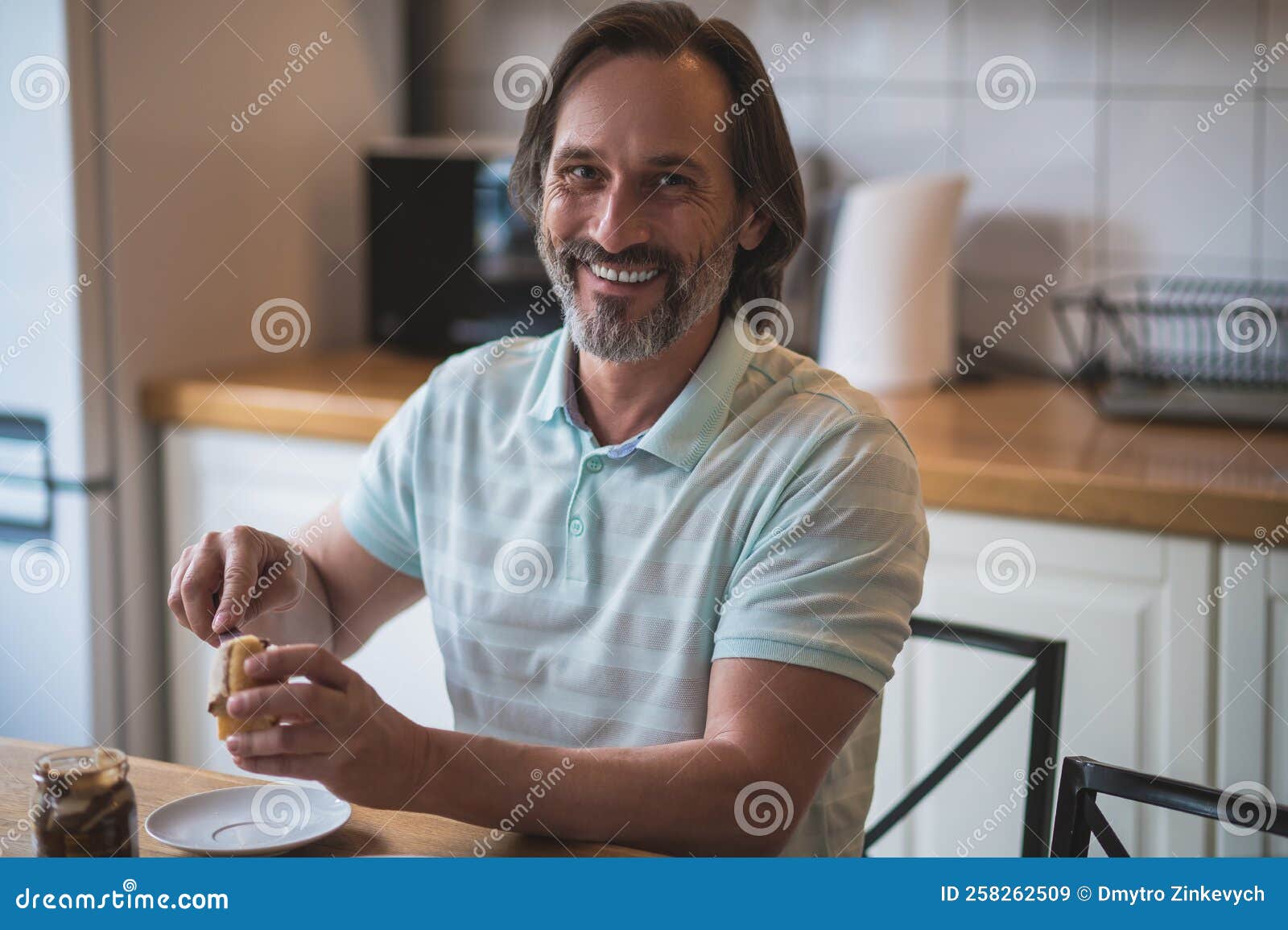 Man in the Kitchen Having Breakfast and Putting Chocolate Paste on ...