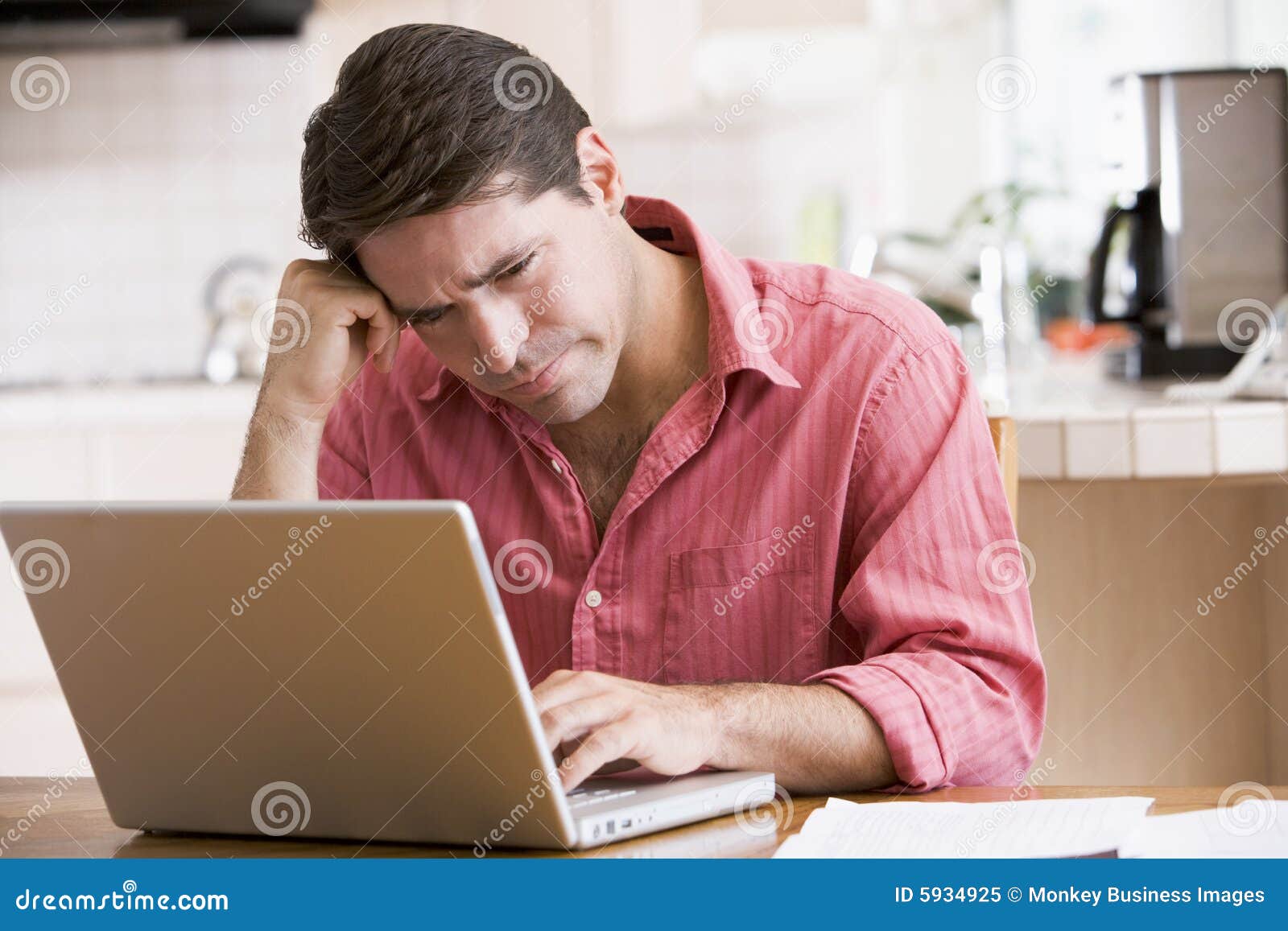 Man in Kitchen Using Laptop Frowning Stock Image - Image of seated ...