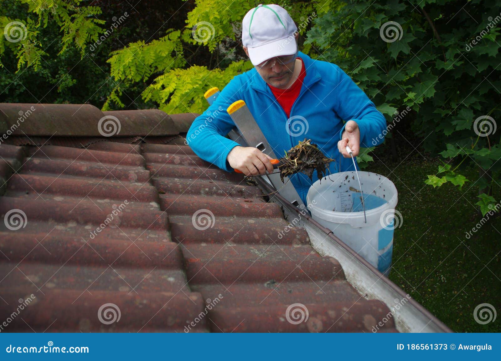 Man on Ladder Cleans Gutter on the Roof Stock Image - Image of building ...