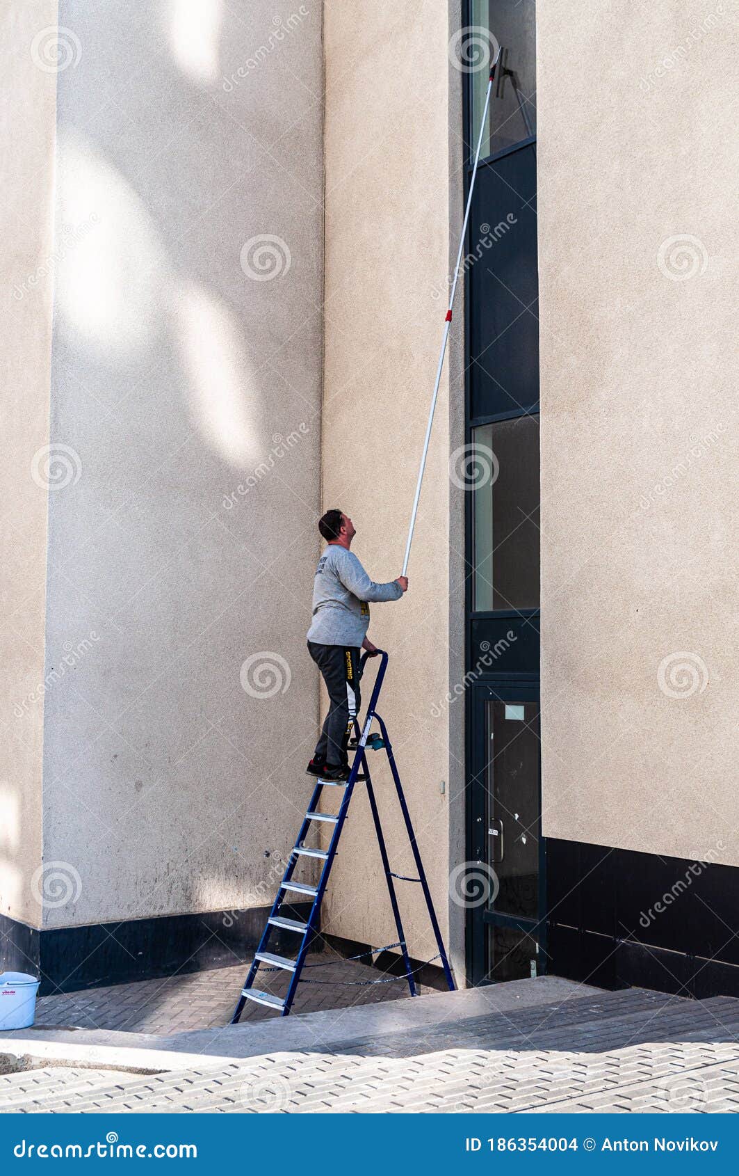 Man on a Ladder Washes Windows Using a Scraper Editorial Stock Image ...