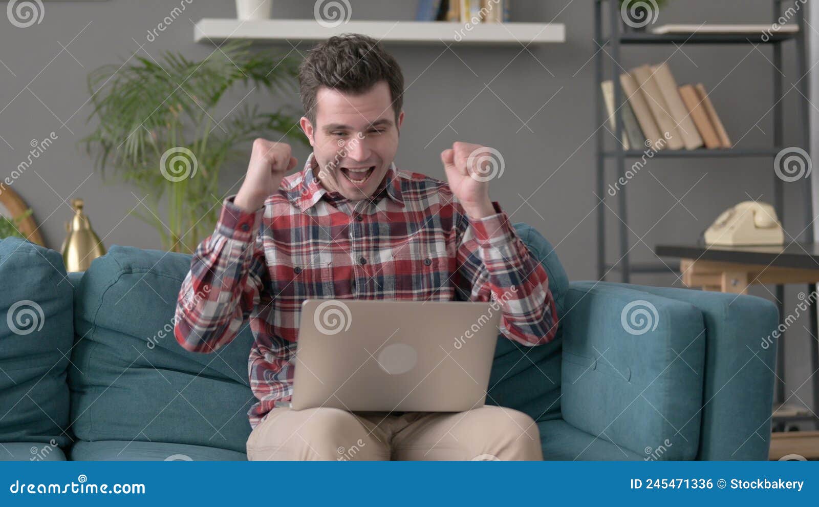 Man with Laptop Celebrating Success on Sofa Stock Photo - Image of ...
