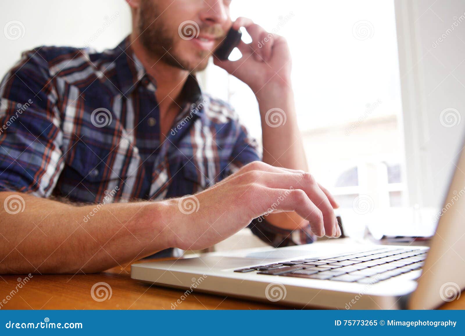 Man on Laptop Computer and Talking on Phone Stock Image - Image of ...
