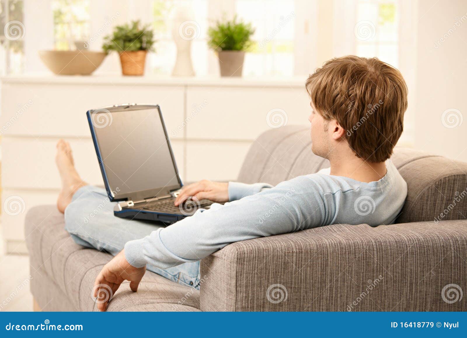 Man with laptop on couch stock image. Image of domestic - 16418779