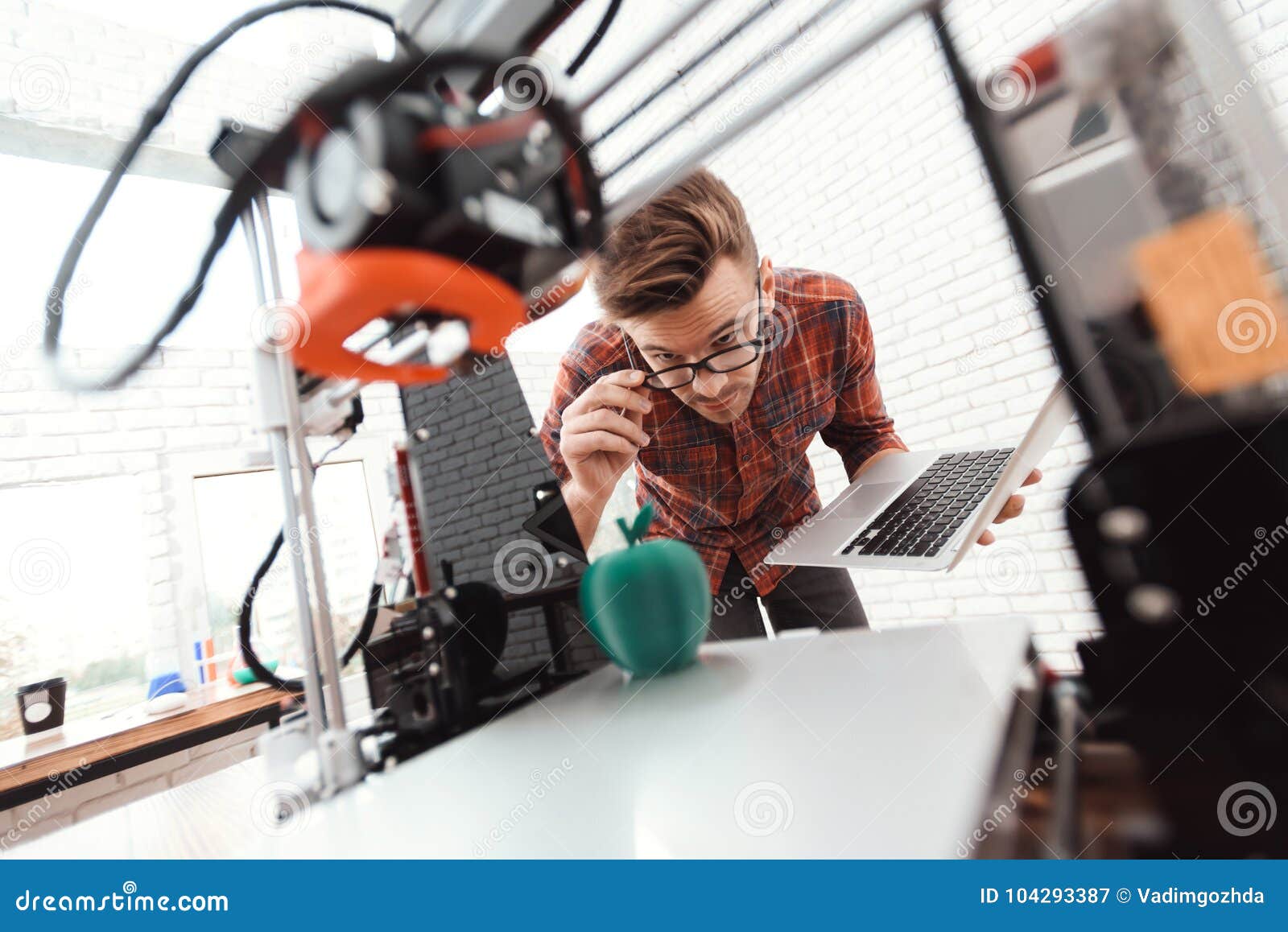 A Man with a Laptop in His Hands Controls the Process of Printing a 3d ...