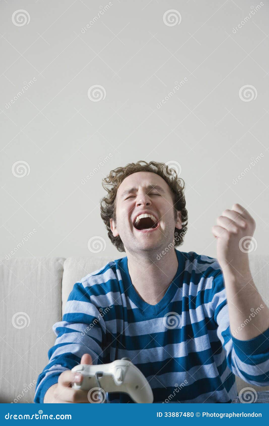 Man Laughing while Holding Video Game Console Stock Photo - Image of ...
