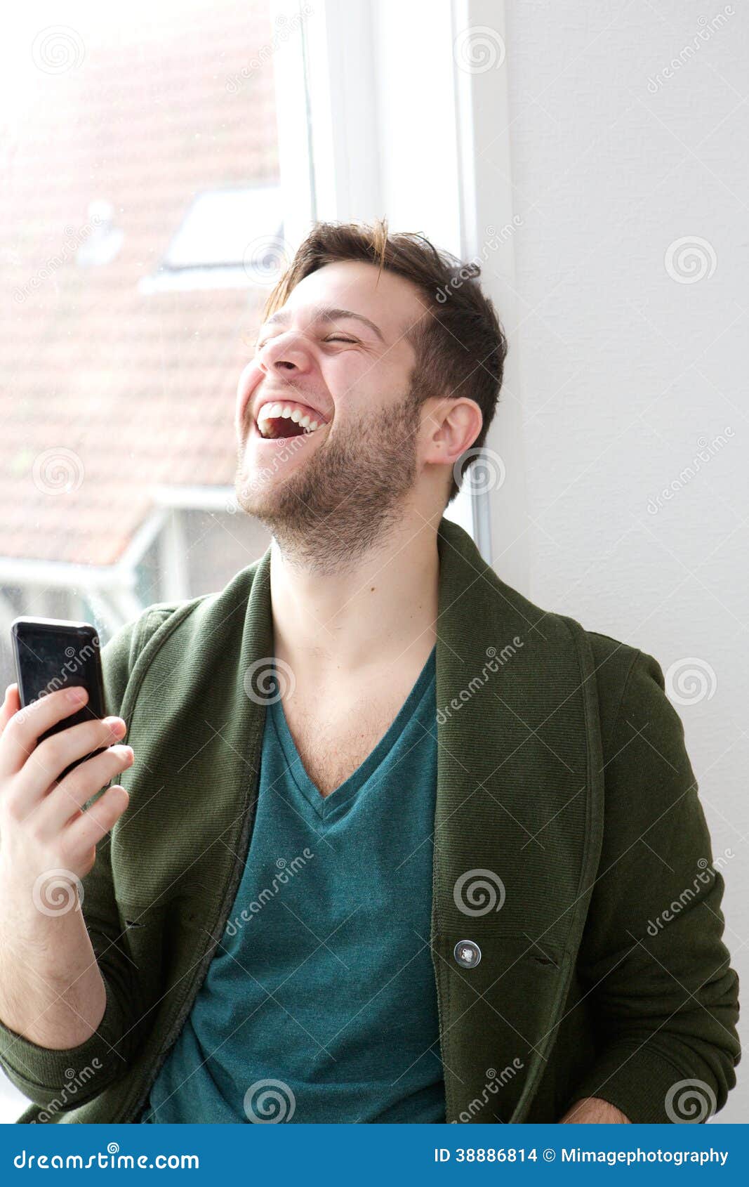 Man Laughing with Mobile Phone Stock Photo - Image of handsome ...