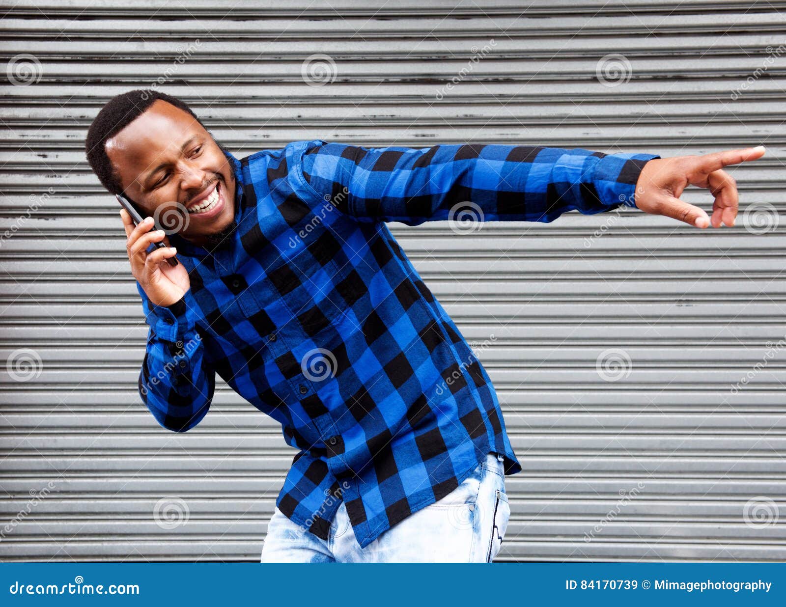 Man Laughing and Pointing Finger while Talking on Mobile Phone Stock ...