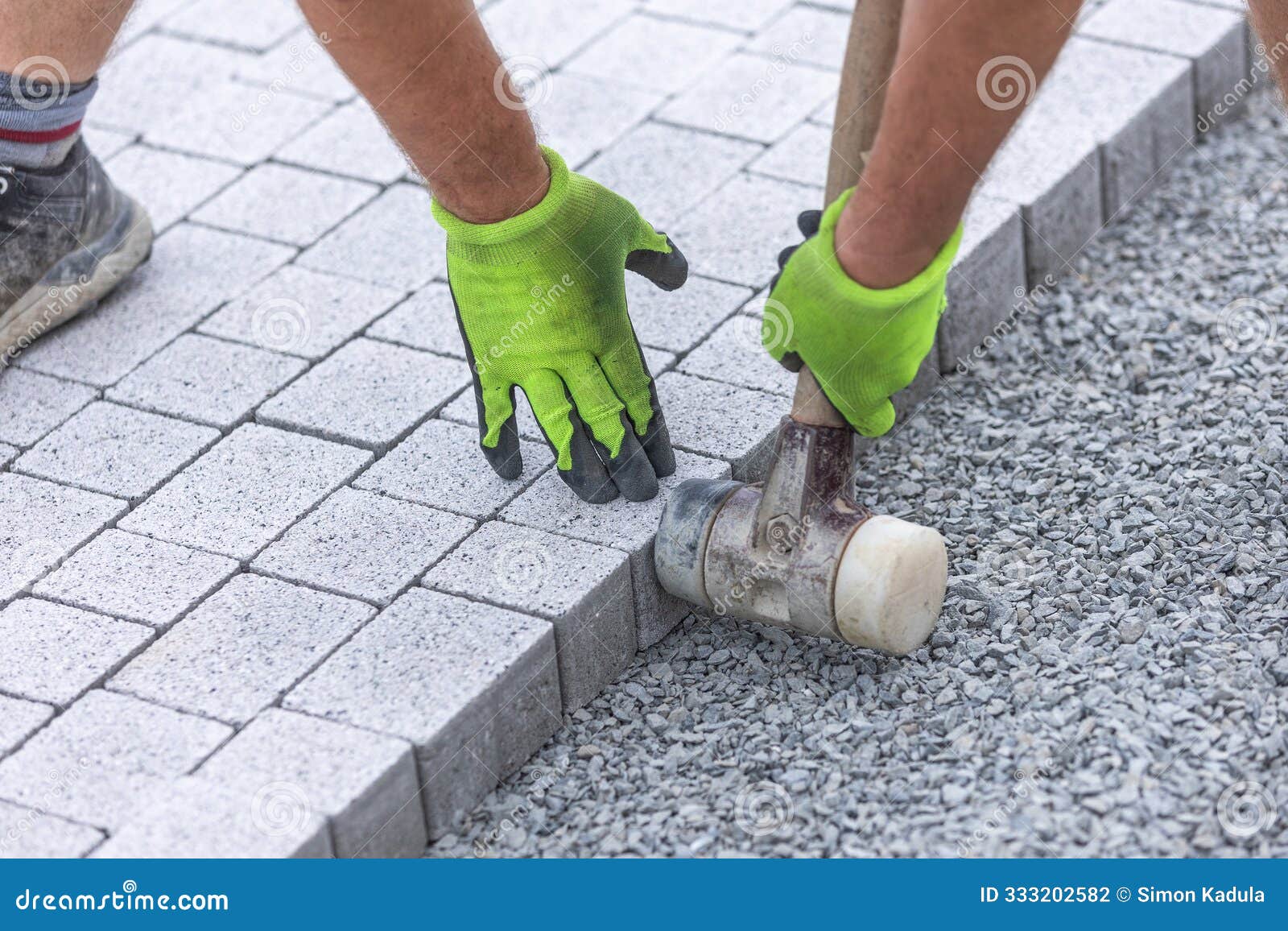 Man Laying Paving Tiles on the Floor Using a Rubber Mallet Stock Photo ...