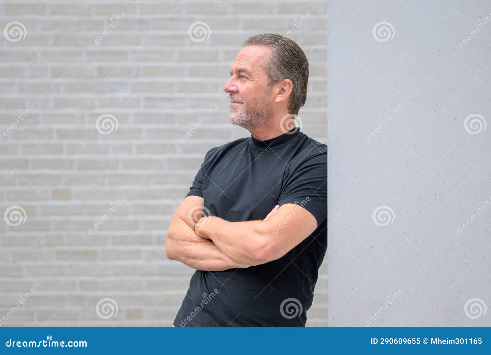Man Leaning Against a Wall with His Arms Crossed and Looking ...