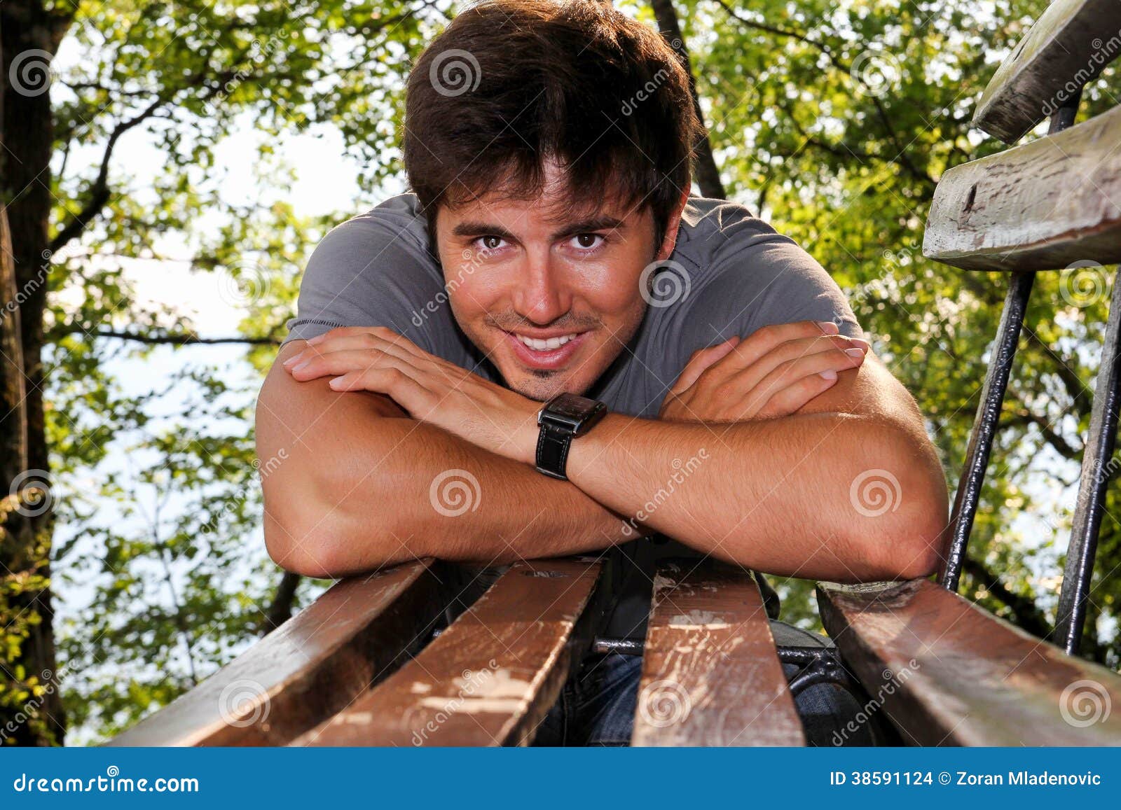 Man Leaning on a Bench in the Park Stock Photo - Image of single, green ...