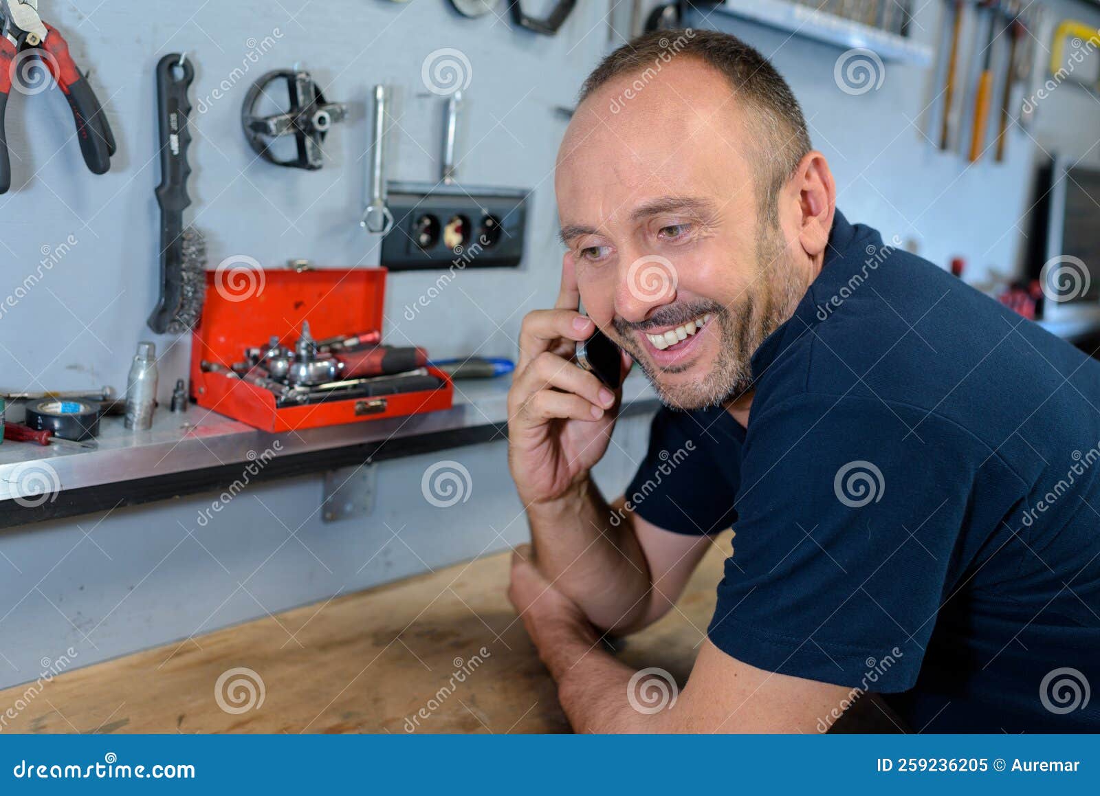 Man Leaning on Bench in Workshop and Talking on Telephone Stock Image ...