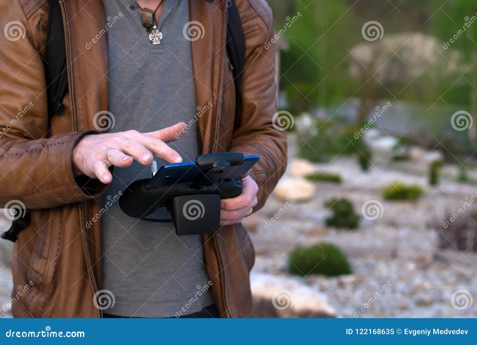 A Man, in a Leather Jacket Controls the Device from the Remote Control ...