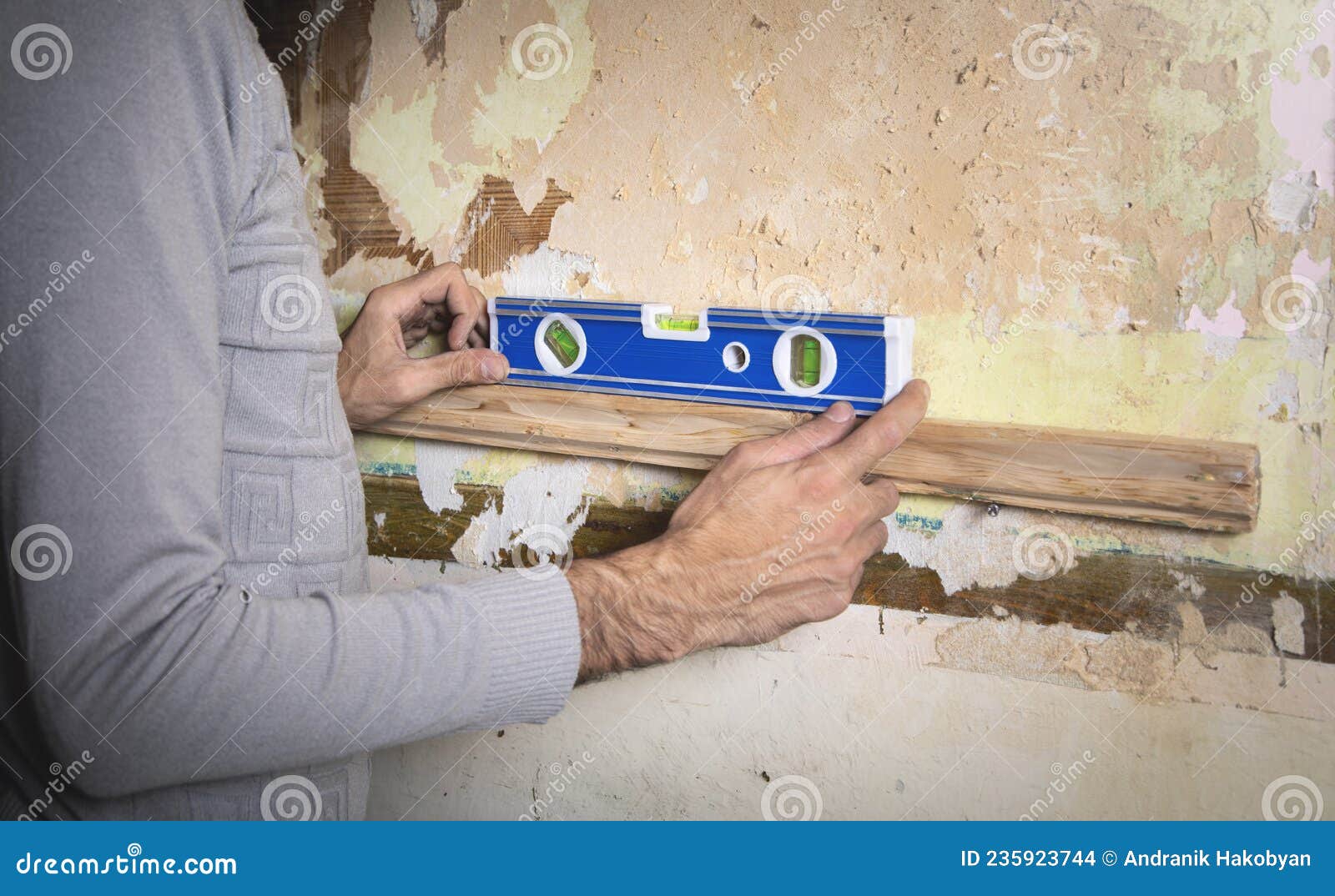 Man with Level Checking the Level of a Plank of Wood Stock Photo ...