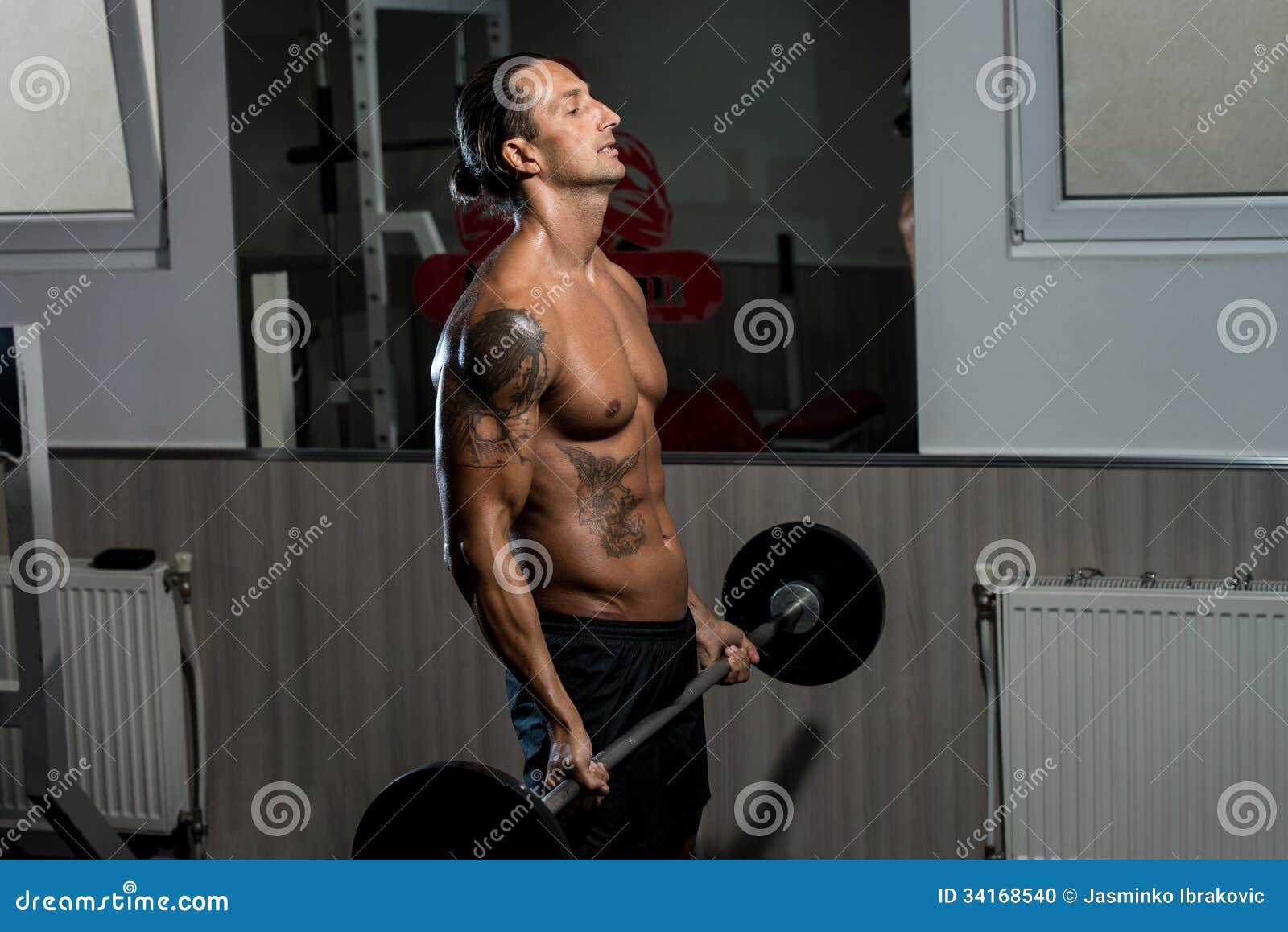 Man Lifting Barbell in Gym stock photo. Image of hear - 34168540
