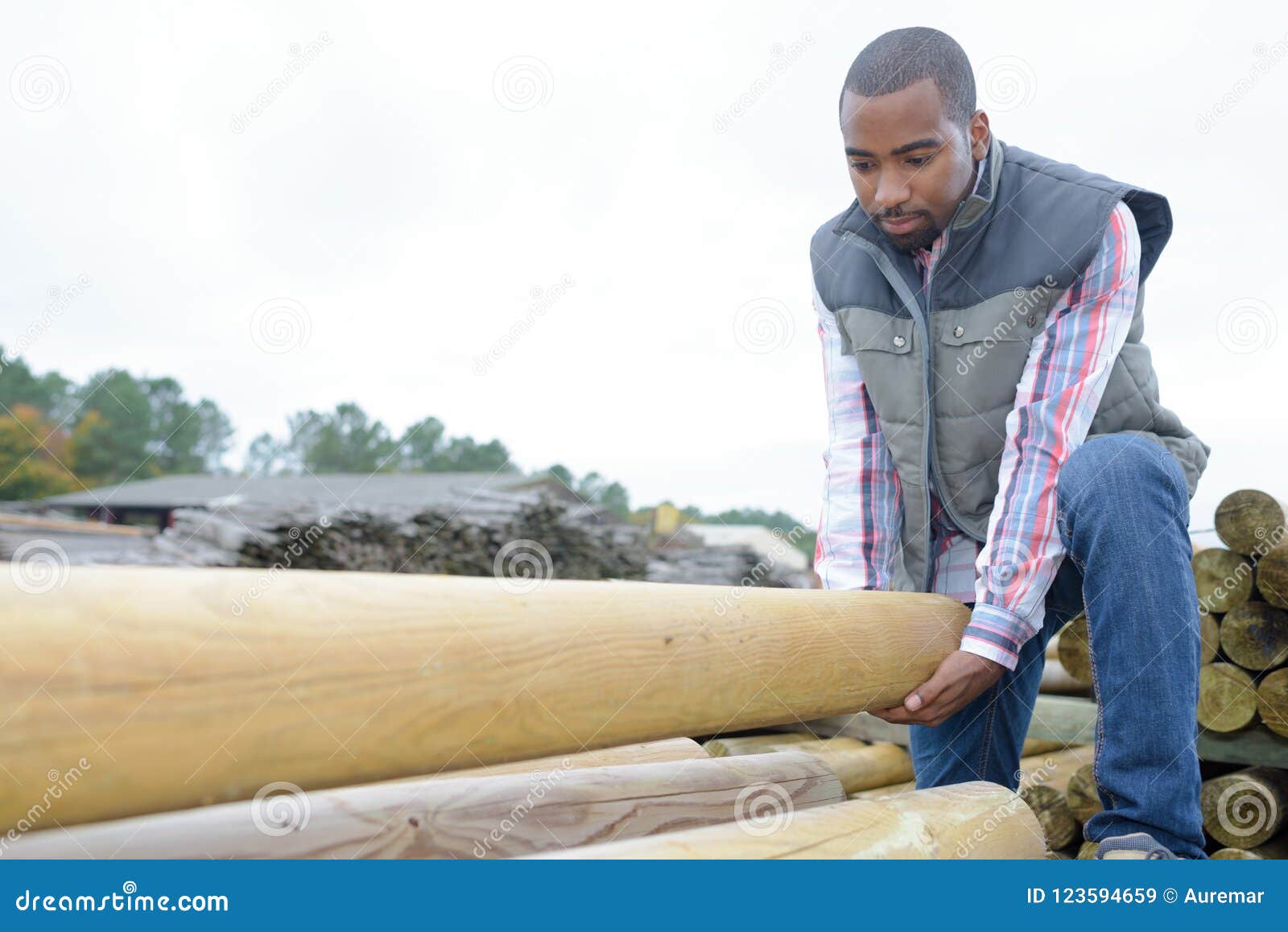Man lifting wooden pole stock image. Image of outdoors - 123594659