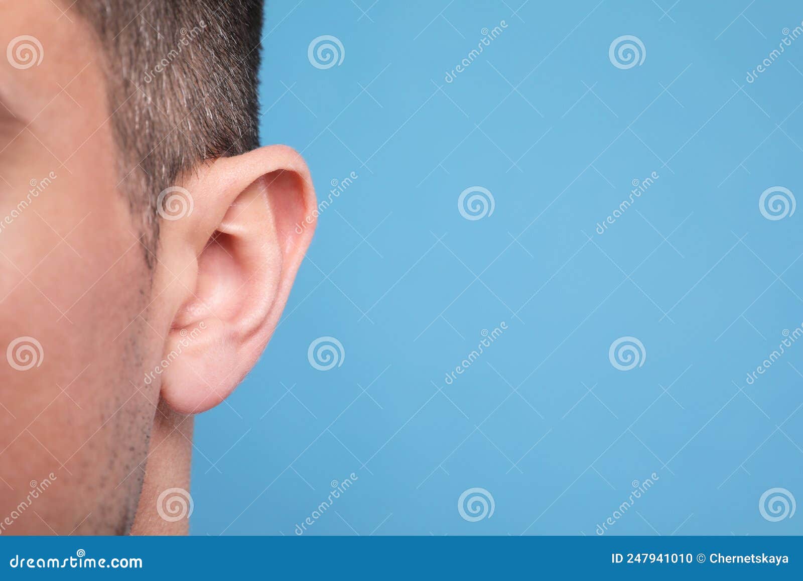 Man on Light Blue Background, Closeup of Ear. Space for Text Stock ...