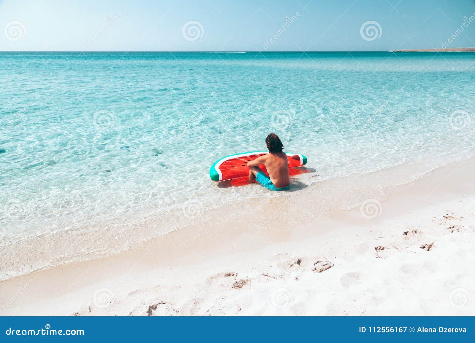 Man on lilo on the beach stock image. Image of travel - 112556167