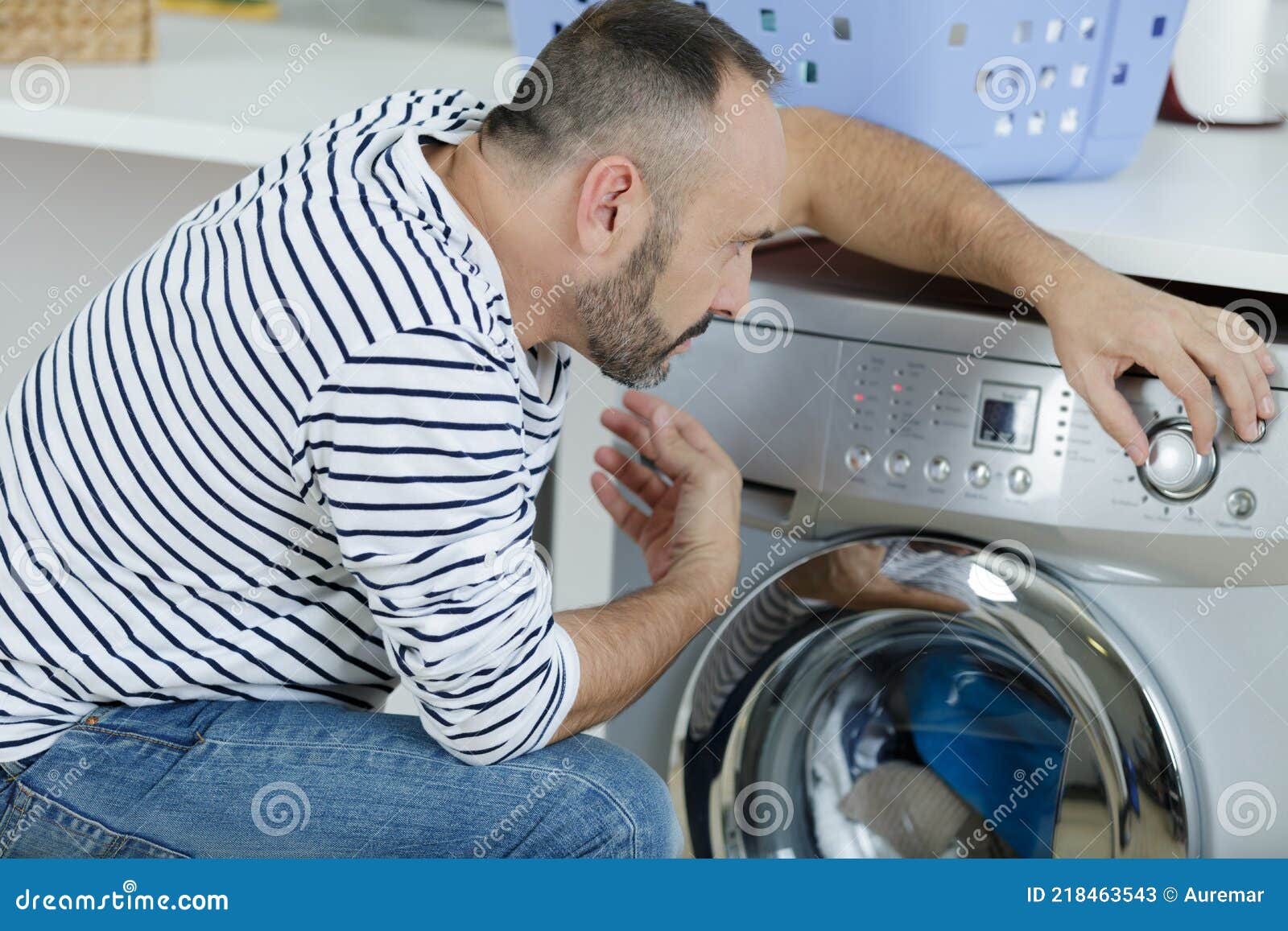 Man Loading Clothes into Washing Machine in Kitchen Stock Image - Image ...