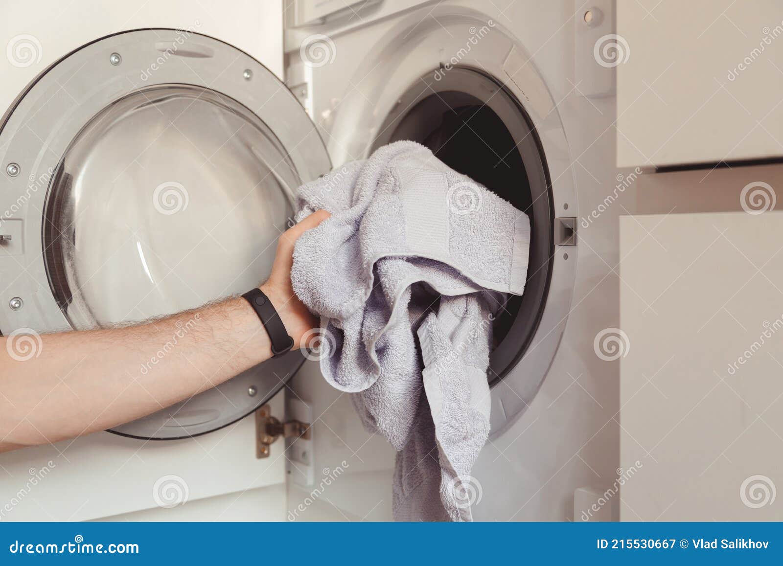 Man Loading Color Clothes and Towels into Built-in Washing Machine ...