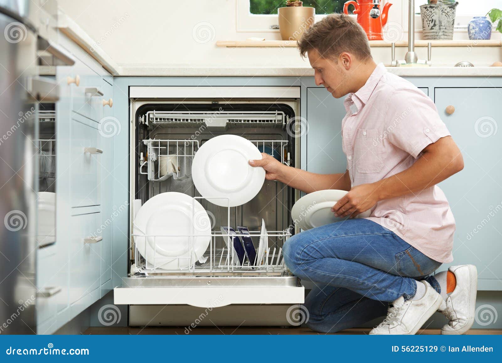 Man Loading Dishwasher in Kitchen Stock Image - Image of casual ...