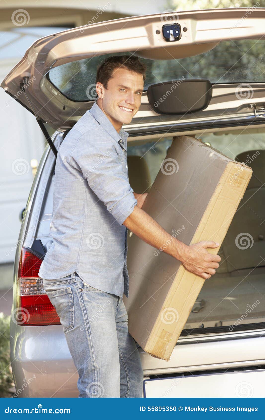 Man Loading Large Package into Back of Car Stock Photo - Image of ...